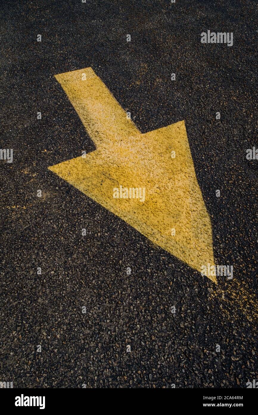 Yellow arrows painted on road or parking lot for directing traffic ...