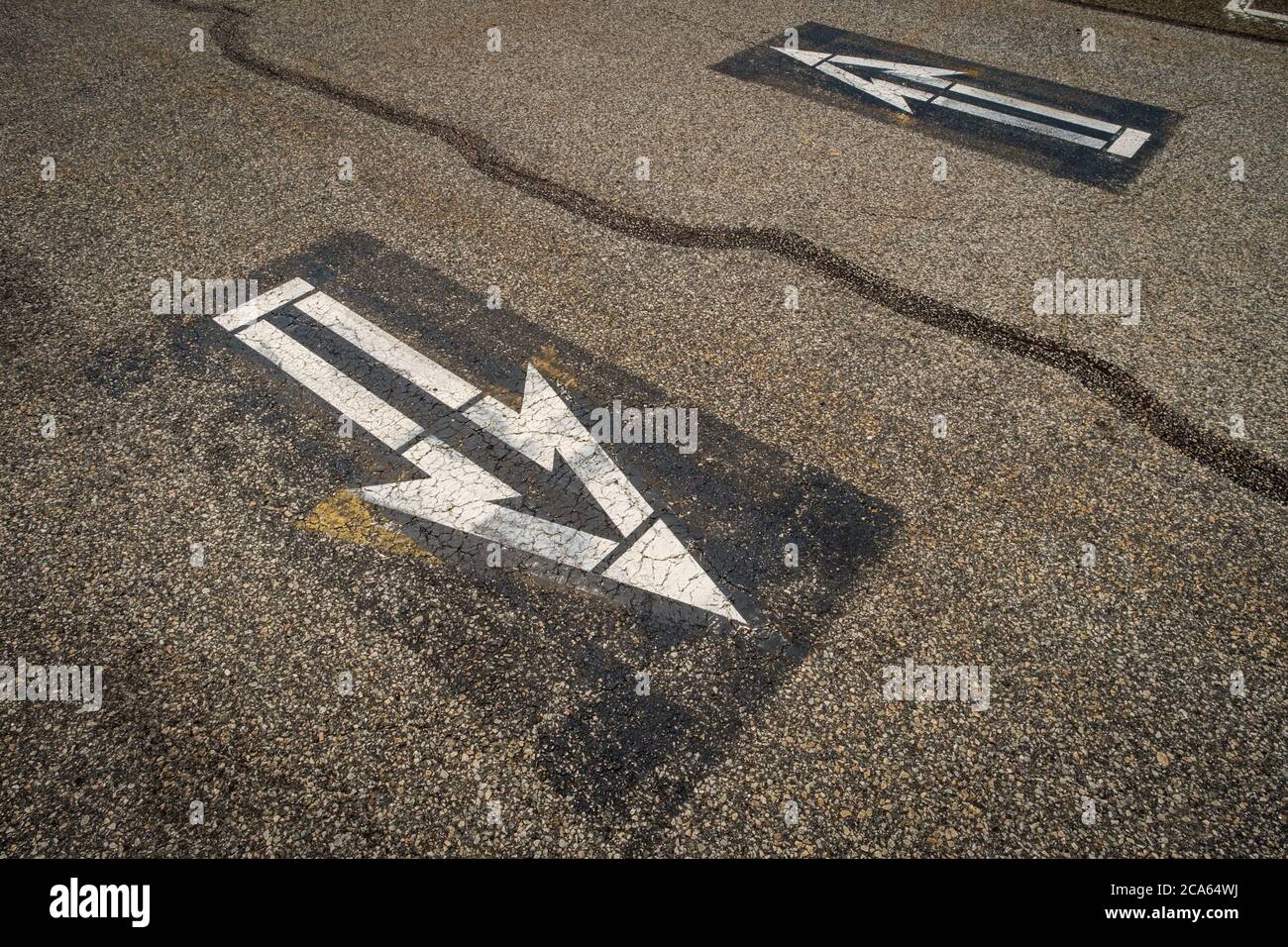 White arrows painted on road or parking lot for directing traffic ...