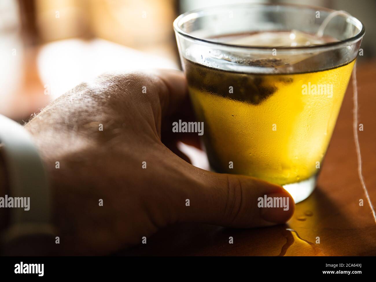 Close-up image of a cold herbal tea: the glass is covered with ...