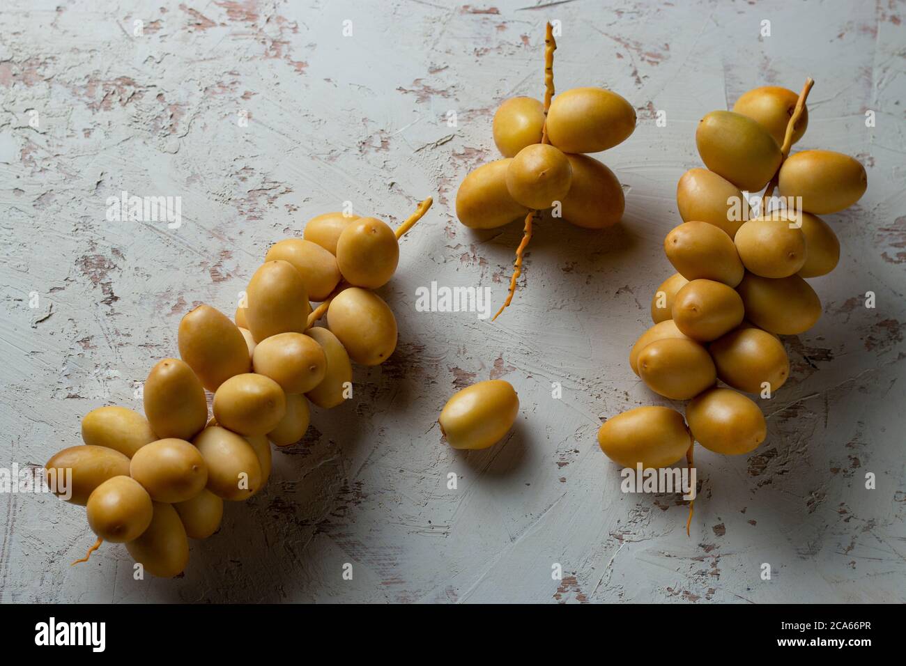 fresh dates fruit on texture white background Stock Photo - Alamy