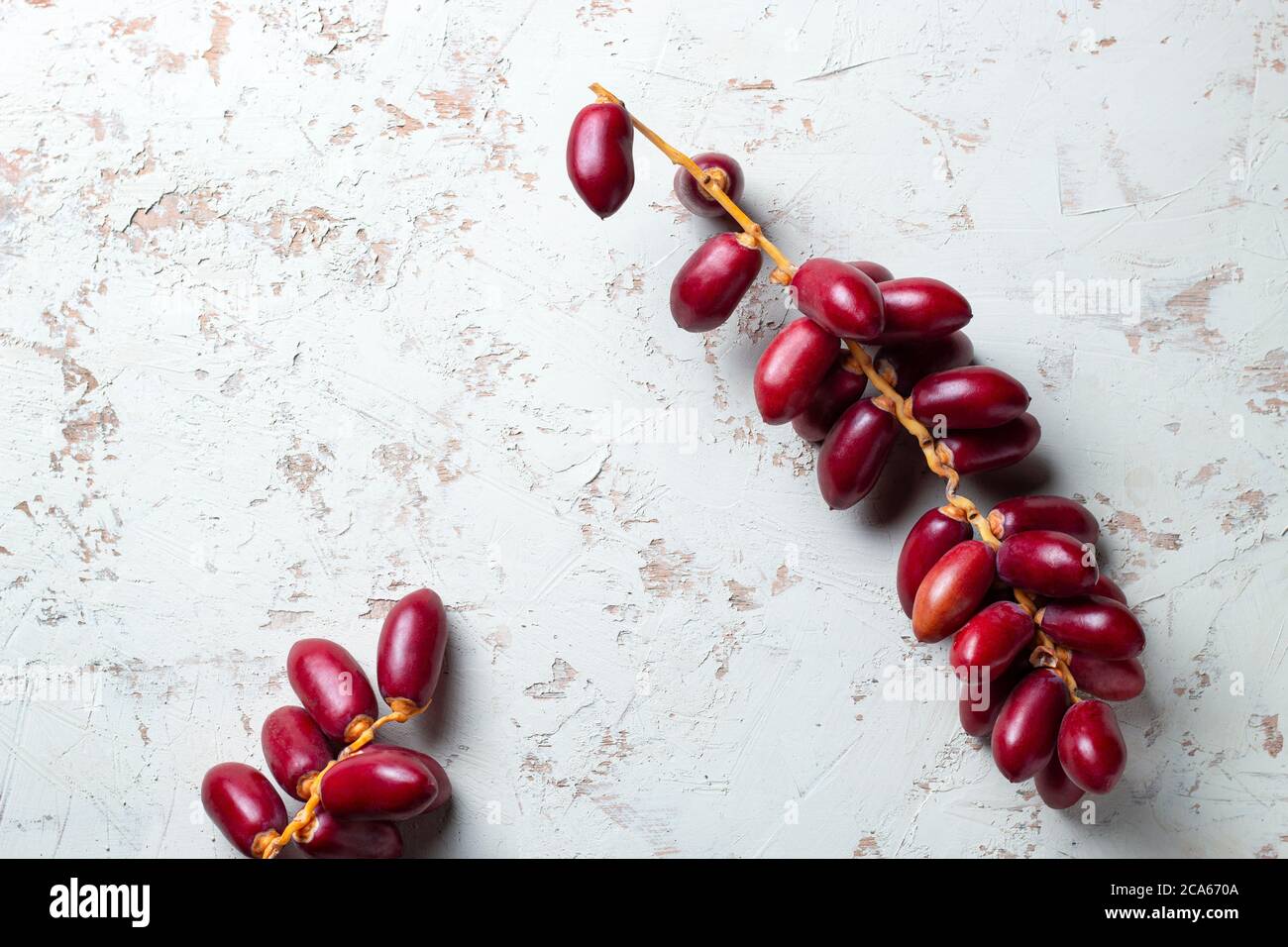 fresh red dates fruits bunch on white background Stock Photo - Alamy
