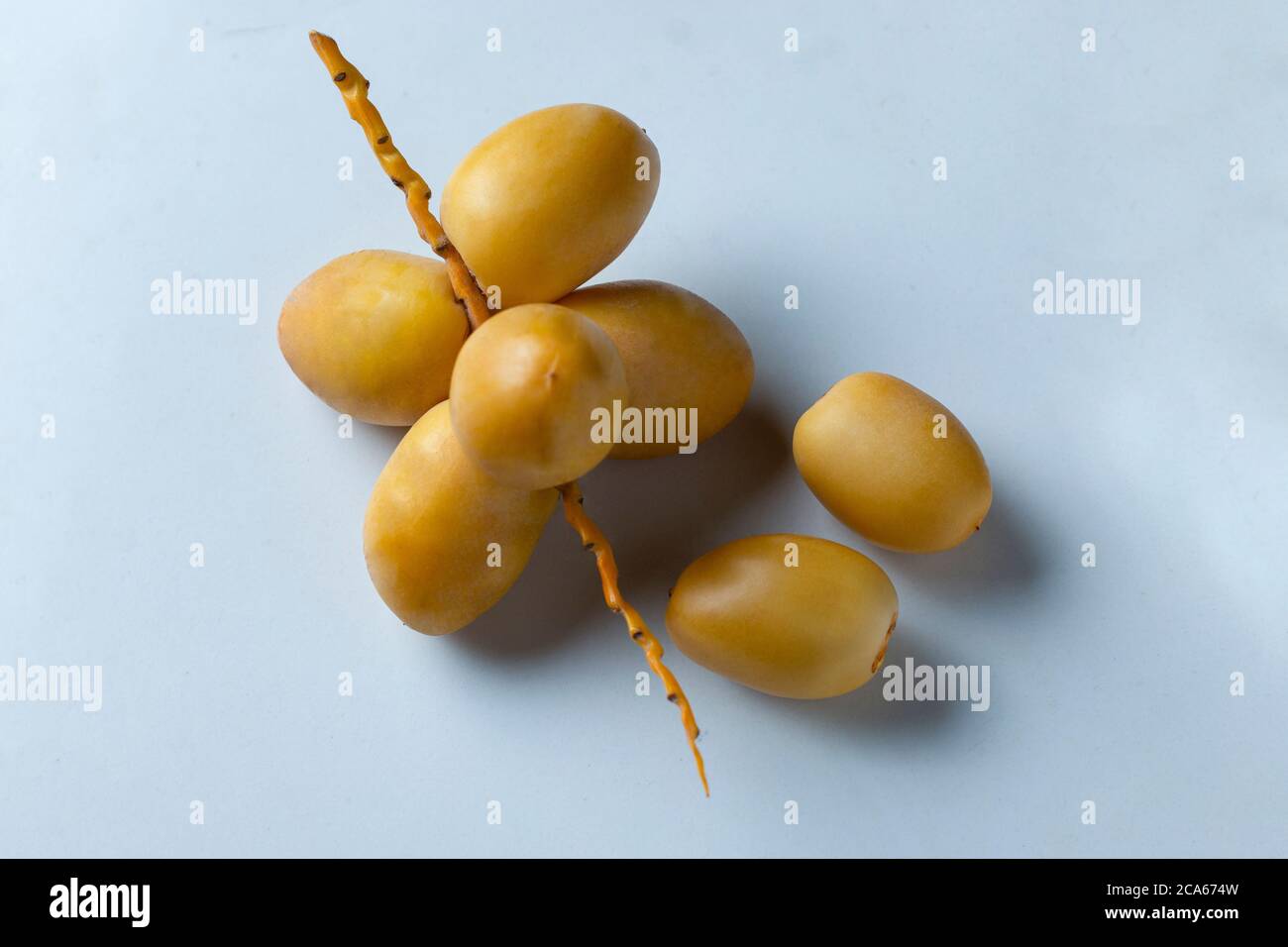 yellow fresh dates fruit on white background Stock Photo - Alamy