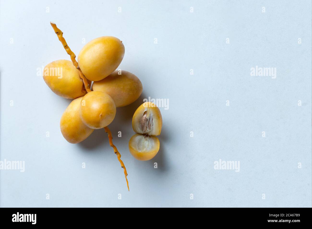 yellow fresh dates fruit on white background Stock Photo - Alamy