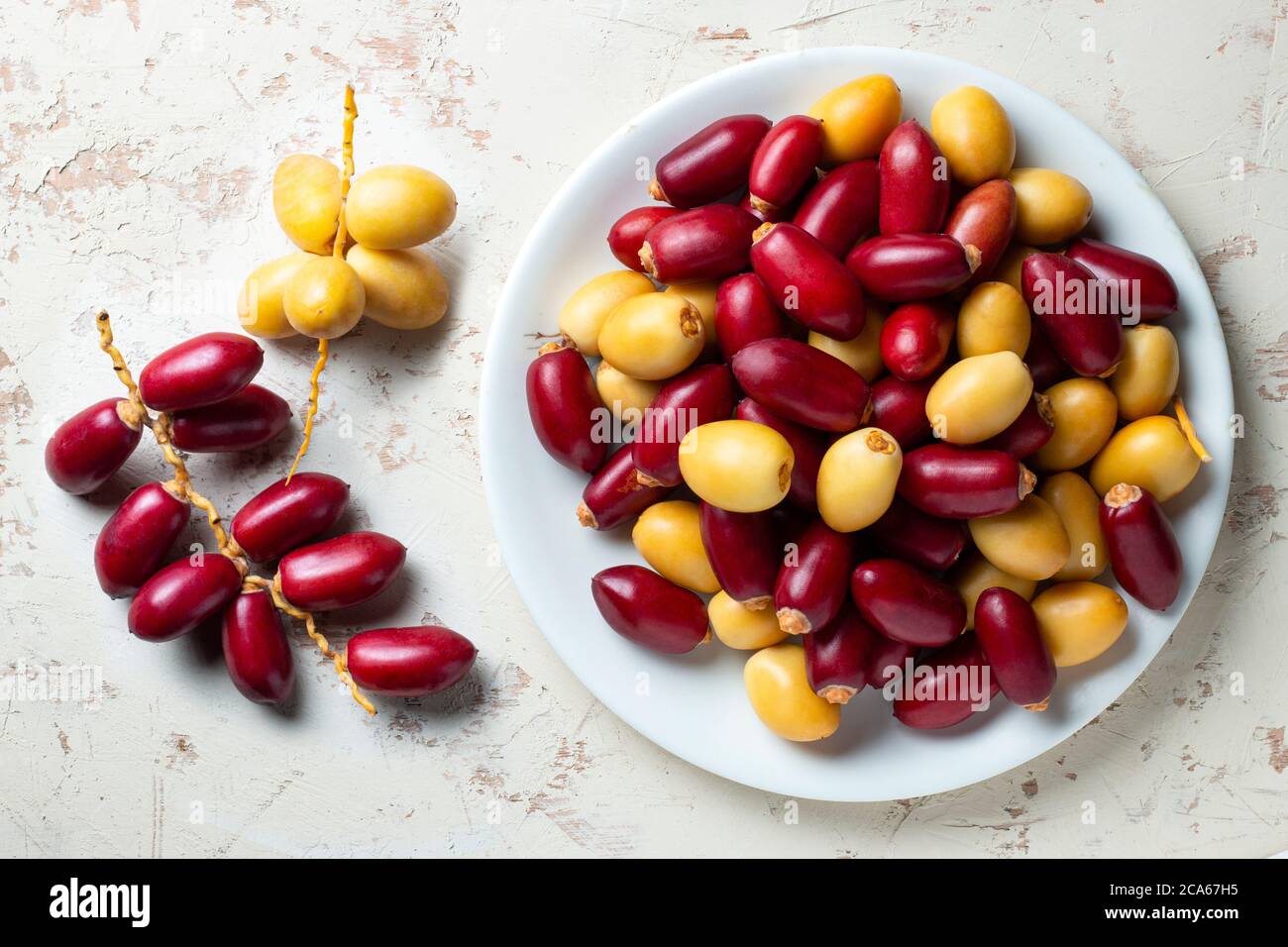 red and yellow fresh dates fruit in white plate Stock Photo - Alamy