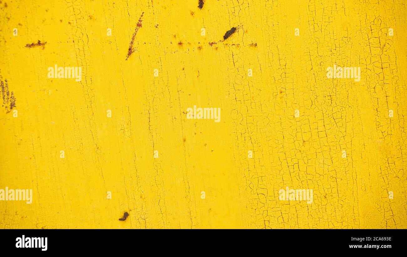 texture of a metal surface with cracked yellow paint and traces of rust ...