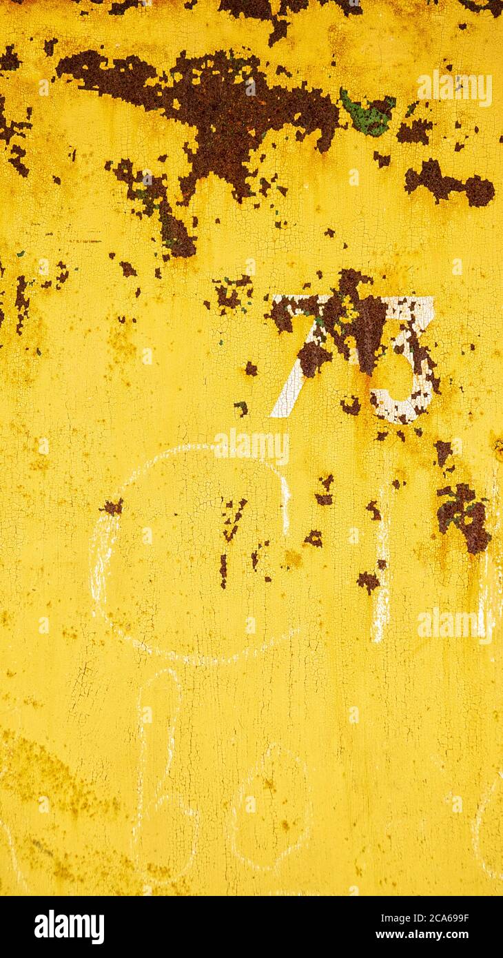 texture of a metal surface with cracked yellow paint and traces of rust ...