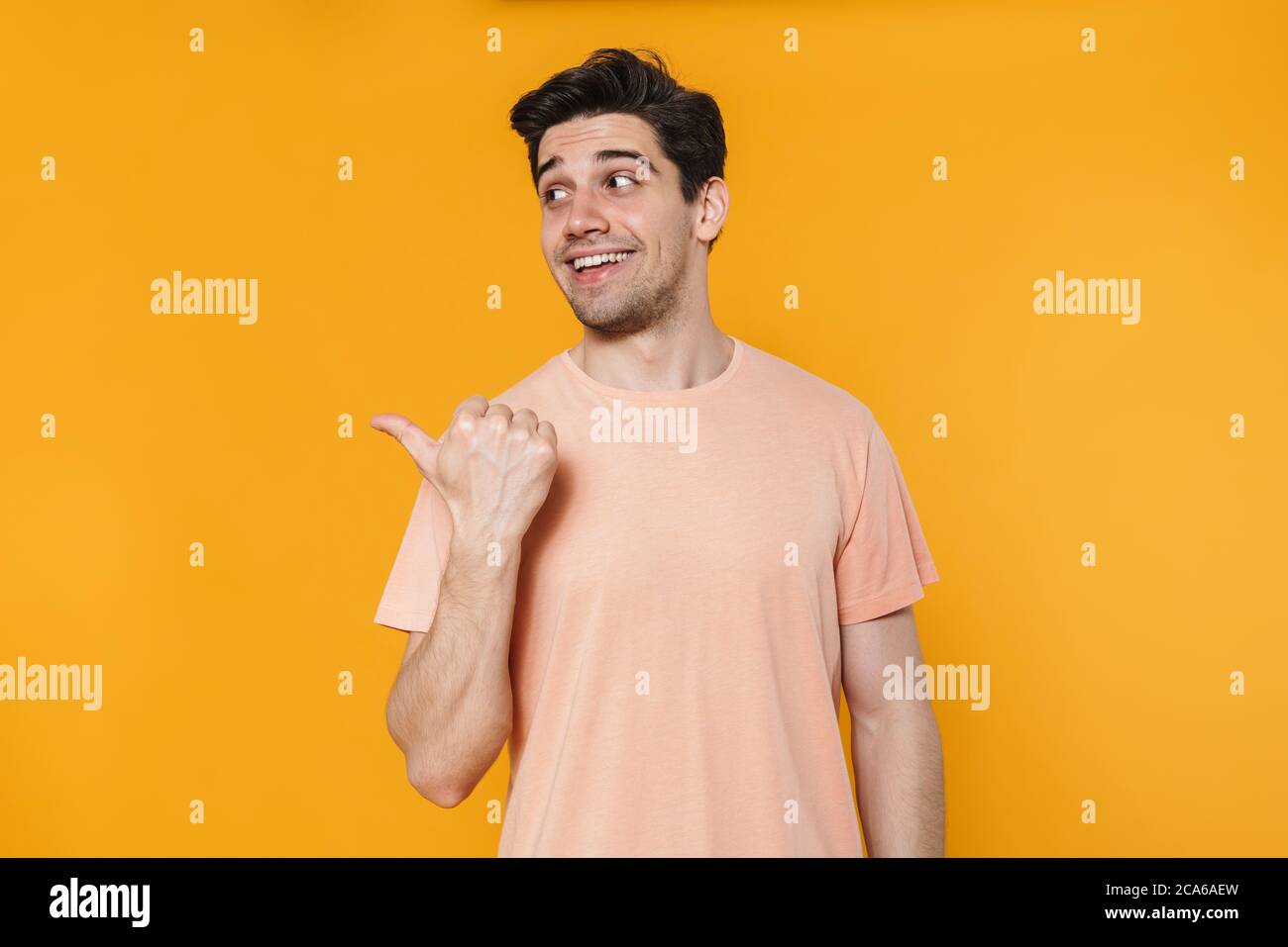 Photo of joyful handsome man smiling and pointing finger aside isolated ...