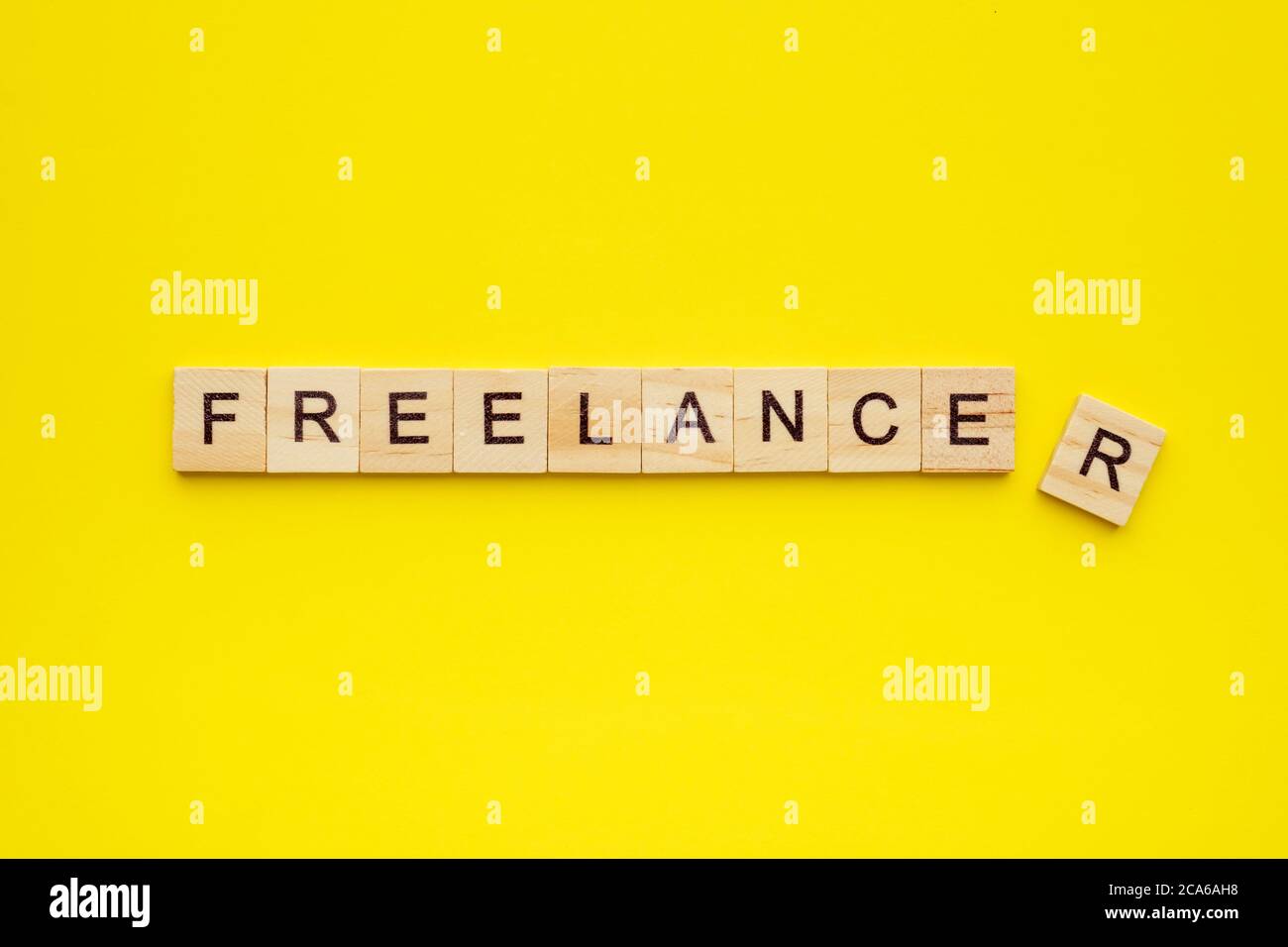 Wooden letters, word freelancer on yellow background Stock Photo - Alamy