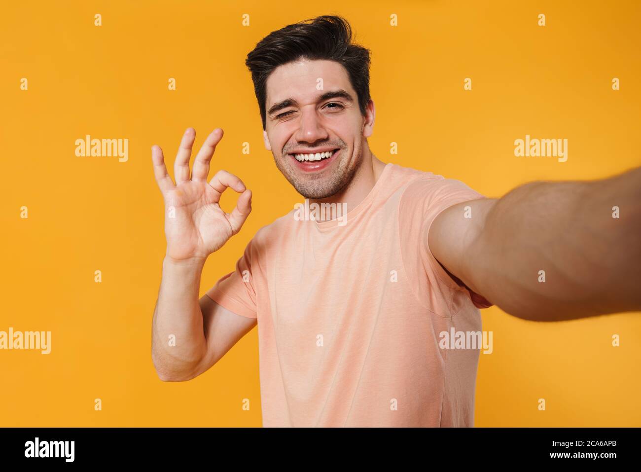 Photo of happy handsome man showing ok sign while taking selfie photo ...
