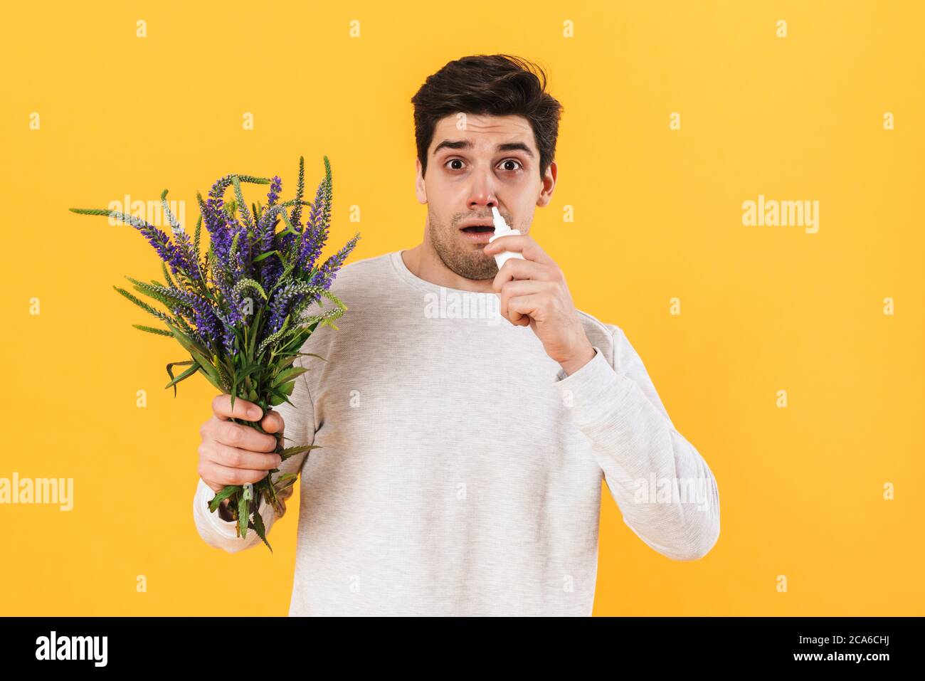 Photo of unhappy man with allergy using nose drops while holding ...