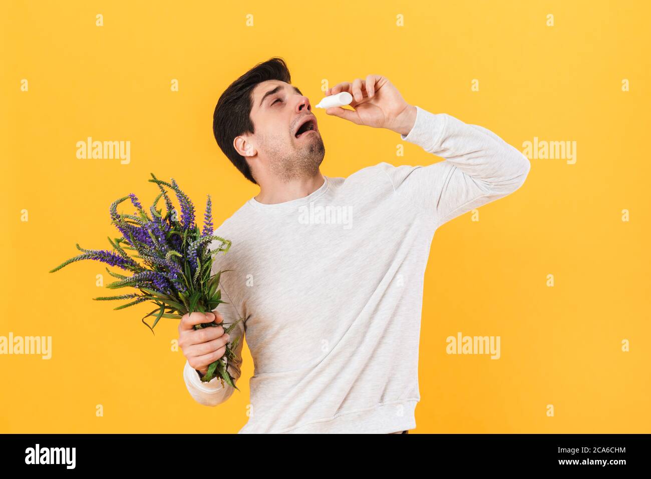 Photo of unhappy man with allergy using nose drops while holding ...