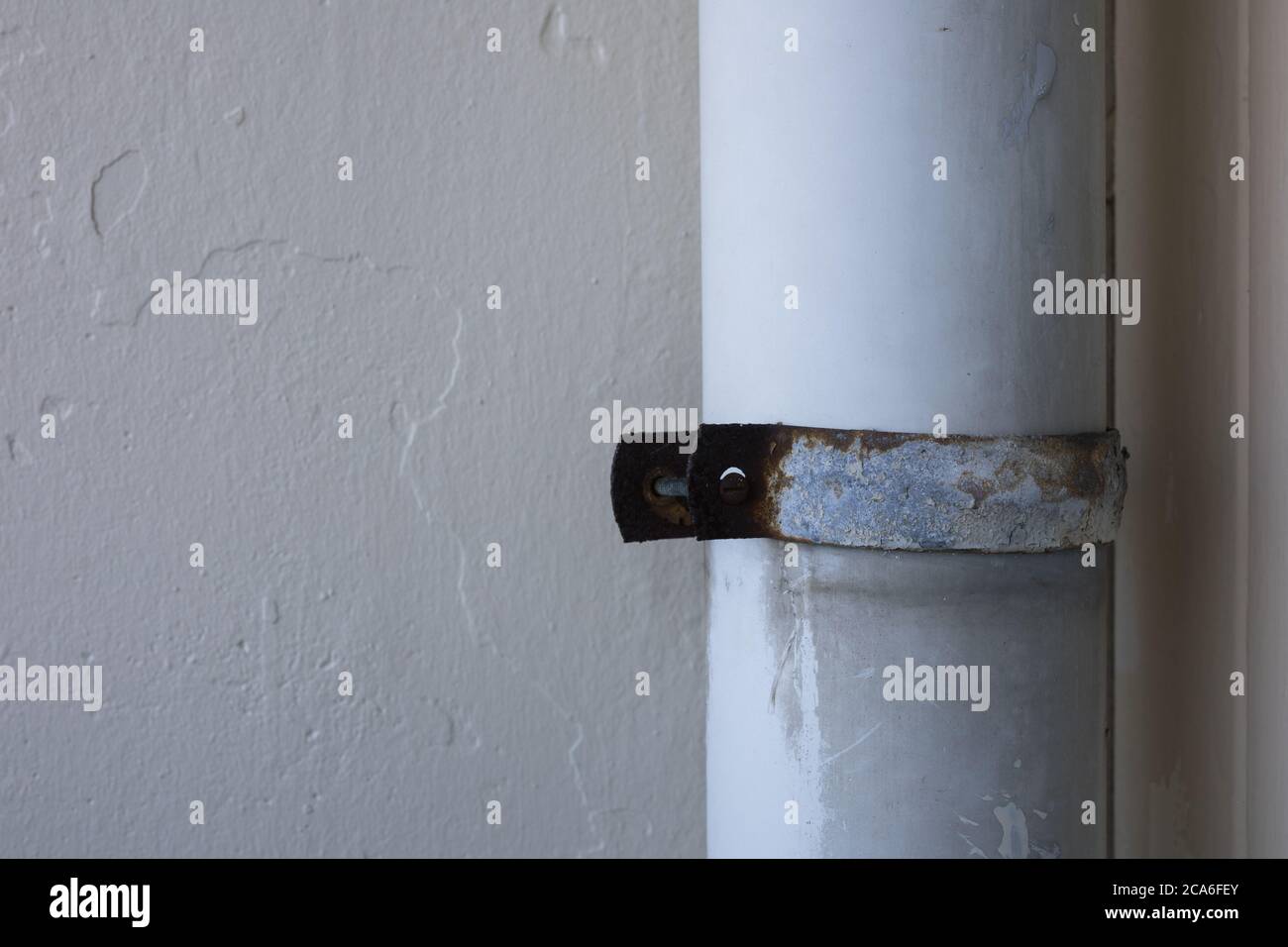 Closeup of a drain pipe with a rusty clamp. Do it yourself, home repair ...