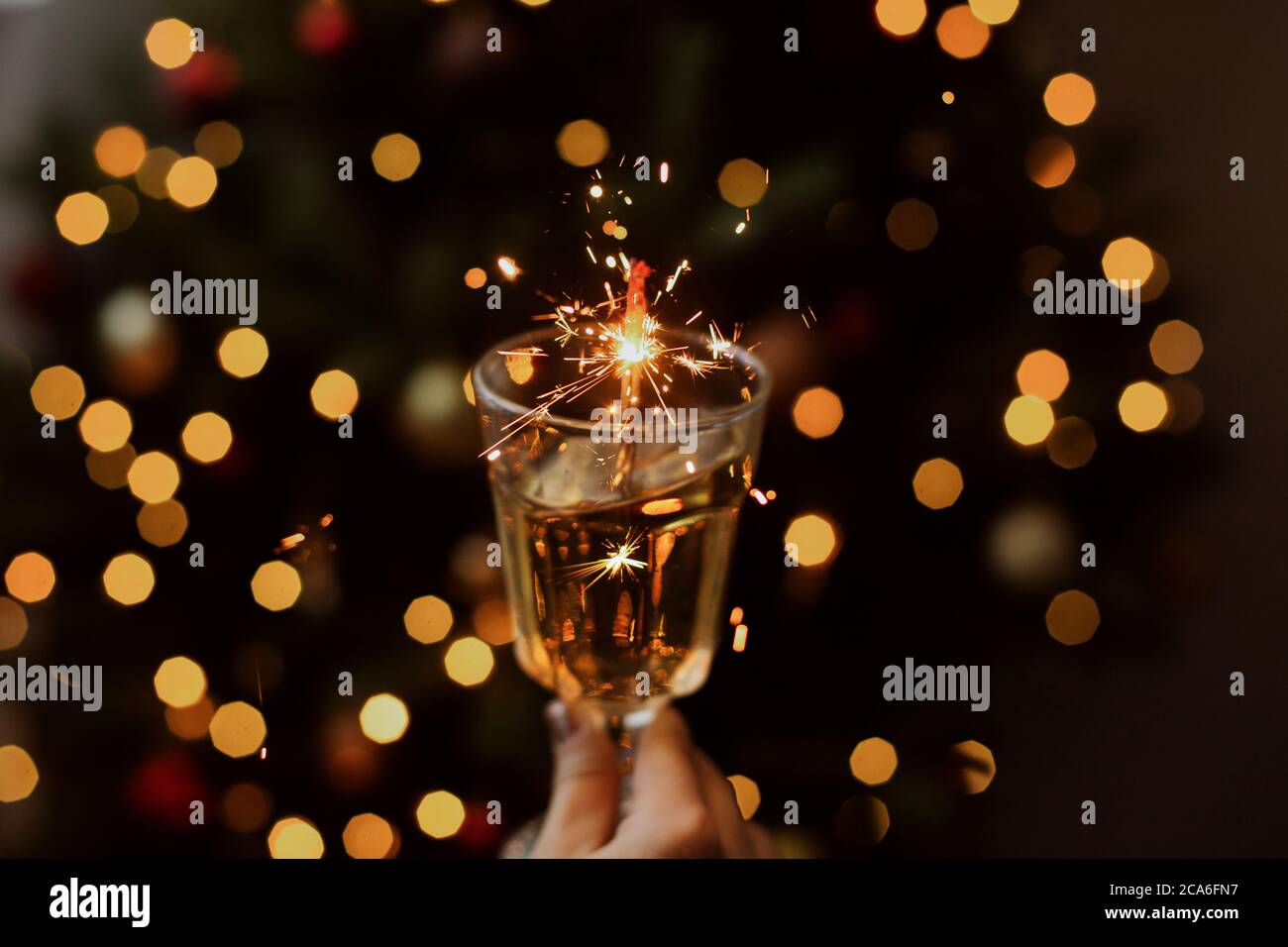 Happy New Year. Burning firework in champagne glass in hand on ...