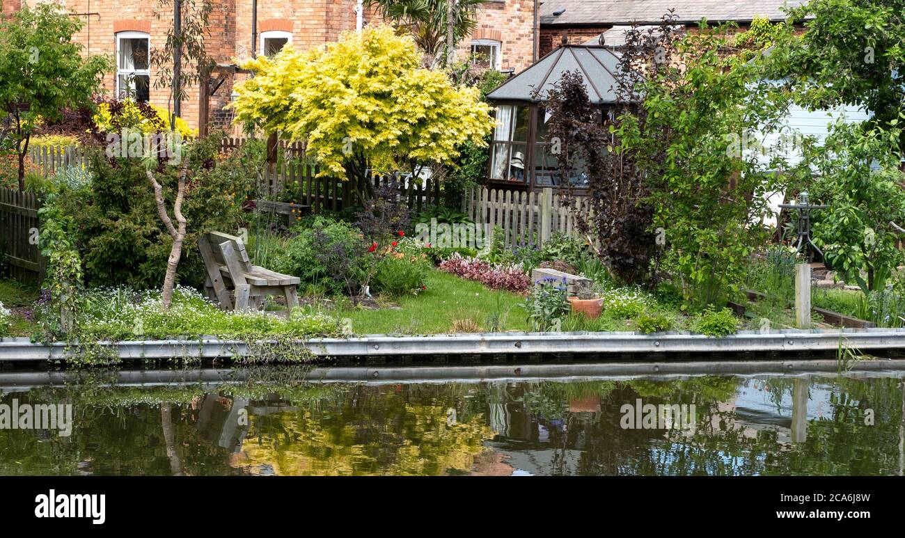 Canal side garden and seating area Stock Photo - Alamy