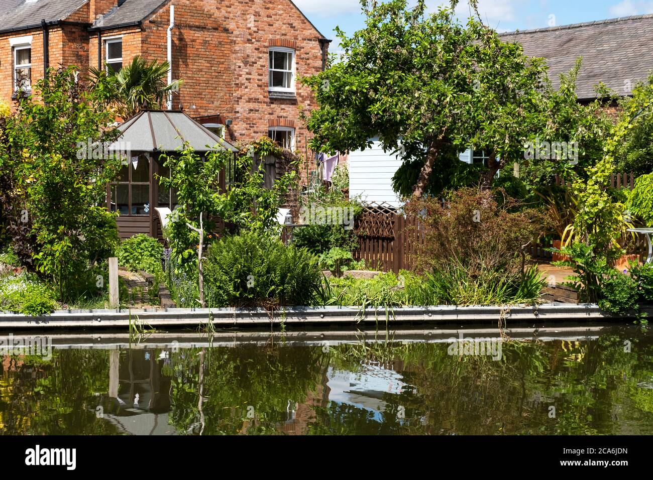 Canal side garden and seating area Stock Photo - Alamy