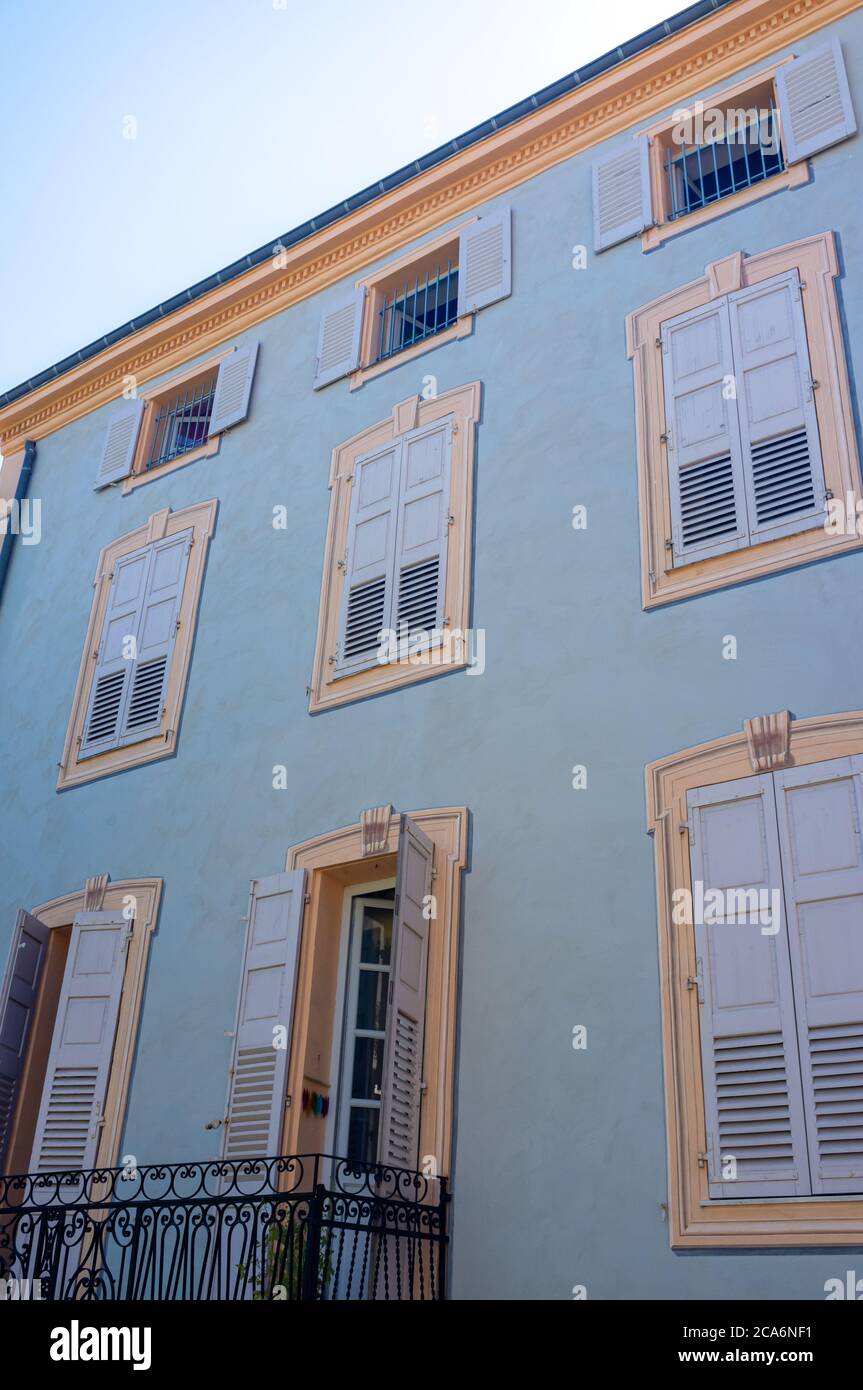 traditional blue and yellow French Riviera facade with painted window ...