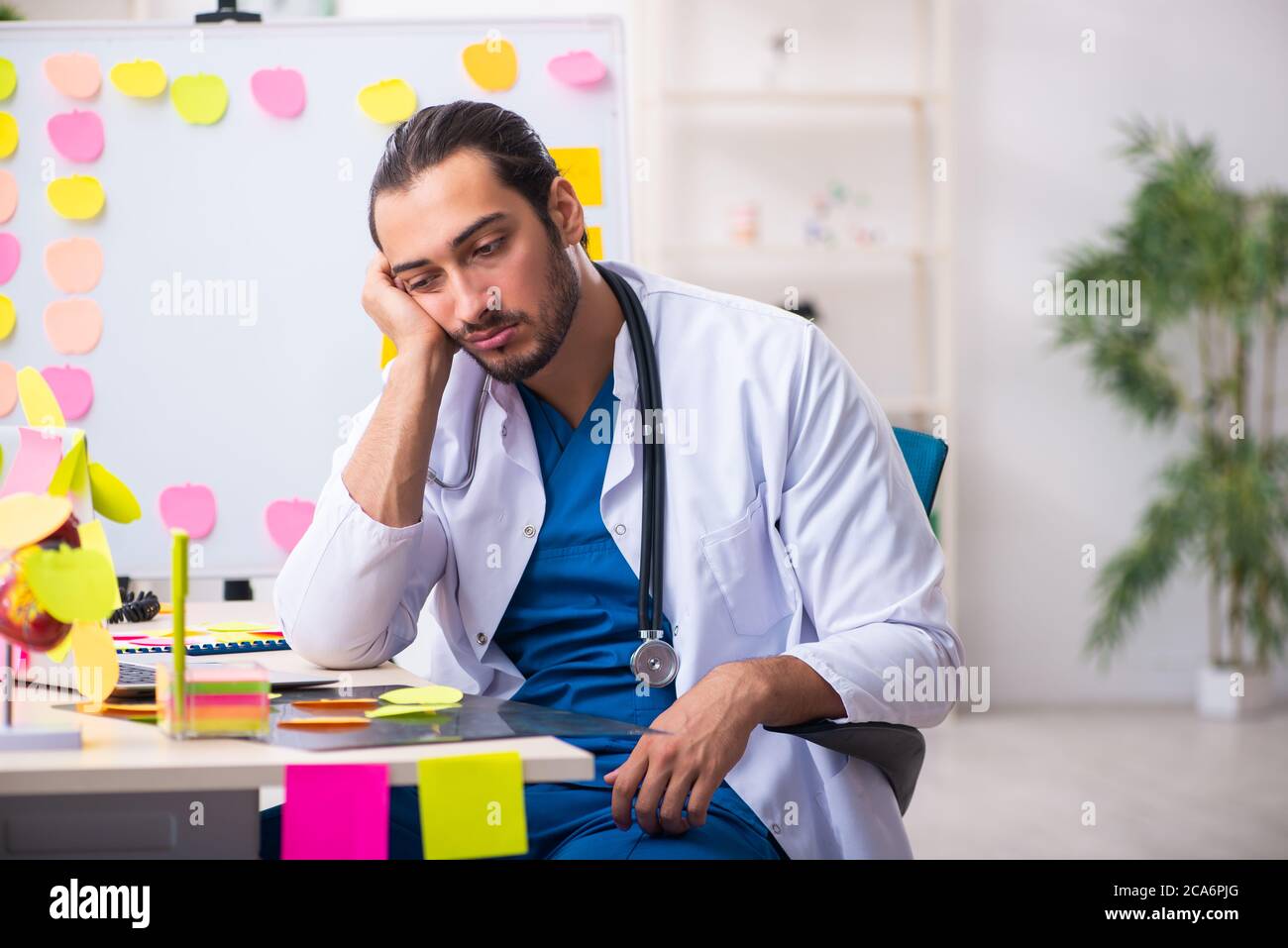 Young medic in conflicting priorities concept Stock Photo - Alamy