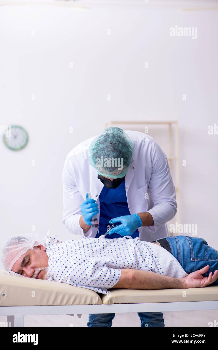 Old man visiting young intern doctor Stock Photo - Alamy