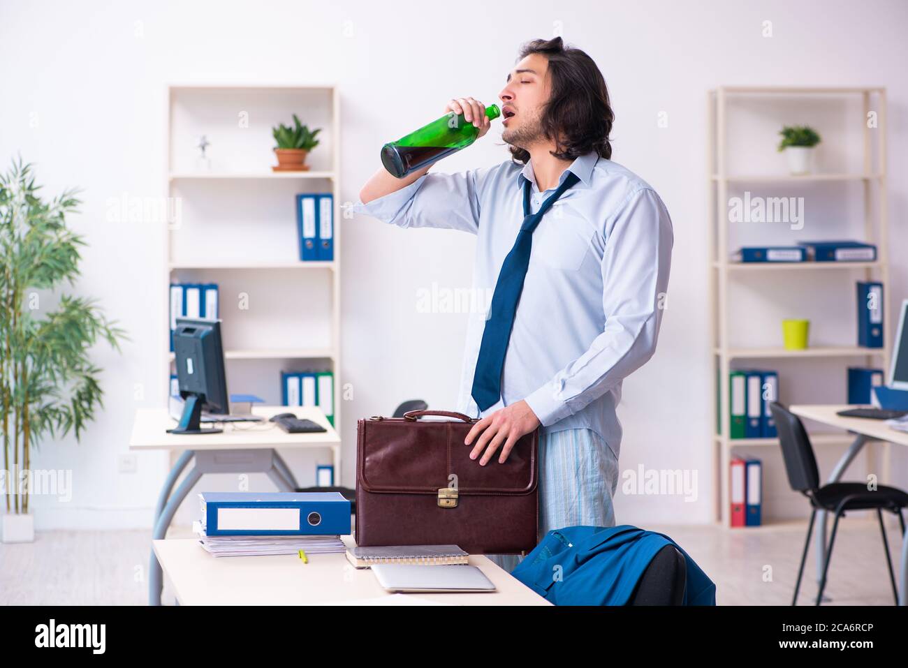 Male employee coming to work after the party Stock Photo - Alamy