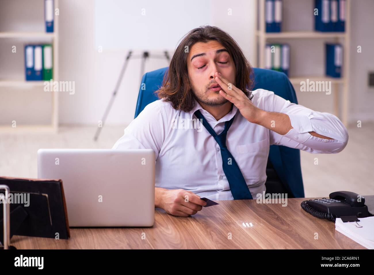 Drug addicted employee working in the office Stock Photo - Alamy