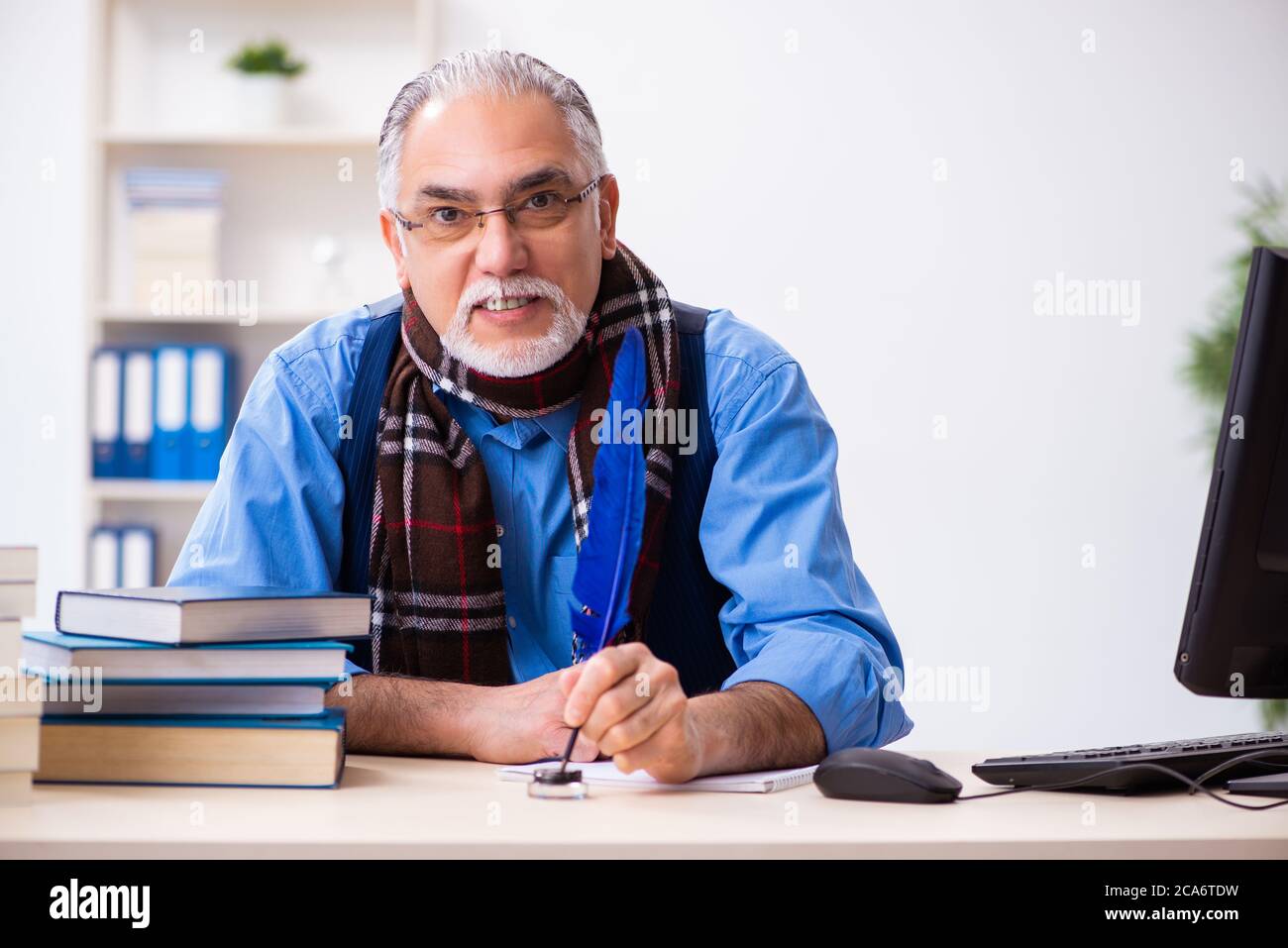Old male author writing books with the feather Stock Photo - Alamy