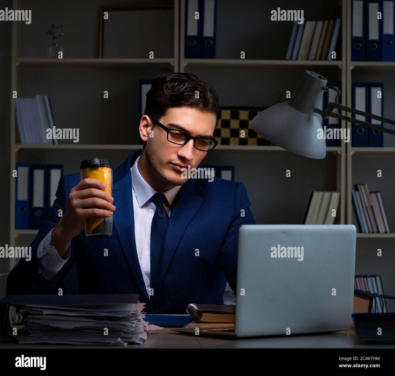 The employee working late and drinking strong coffee to stay awake ...