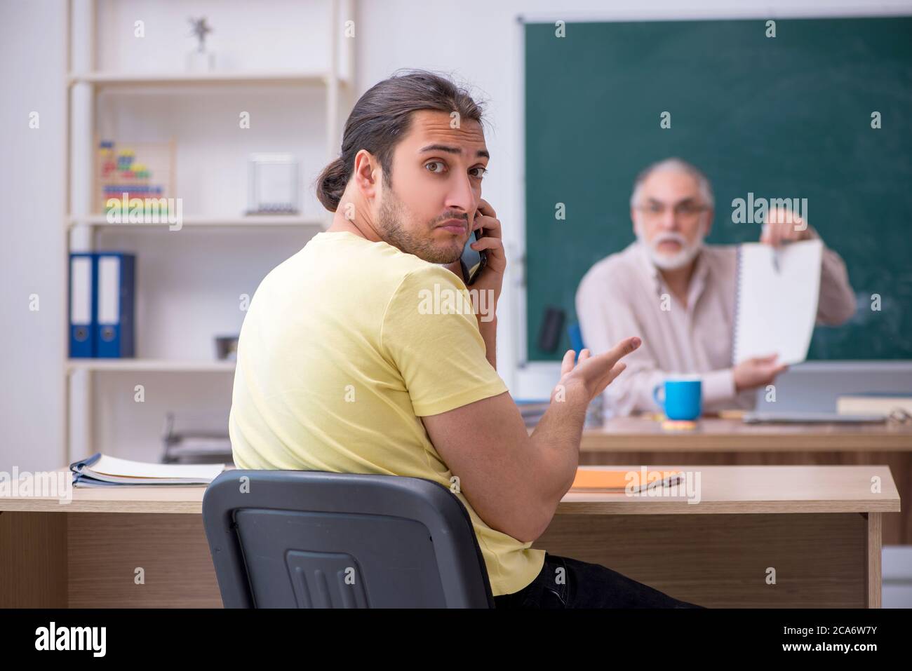 Old teacher and young student in the classroom Stock Photo - Alamy