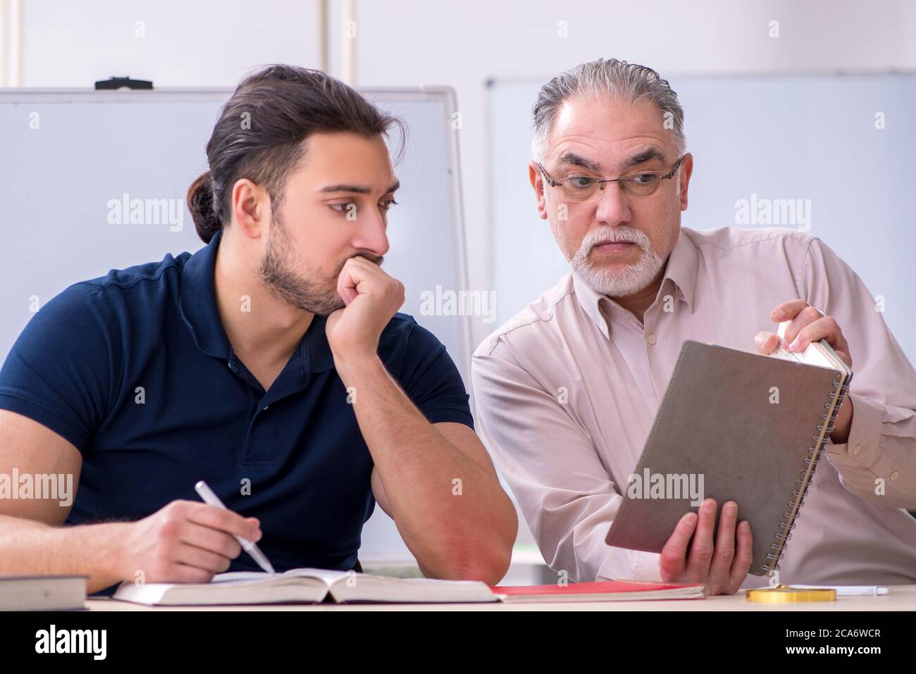 Old teacher and young student in the classroom Stock Photo - Alamy