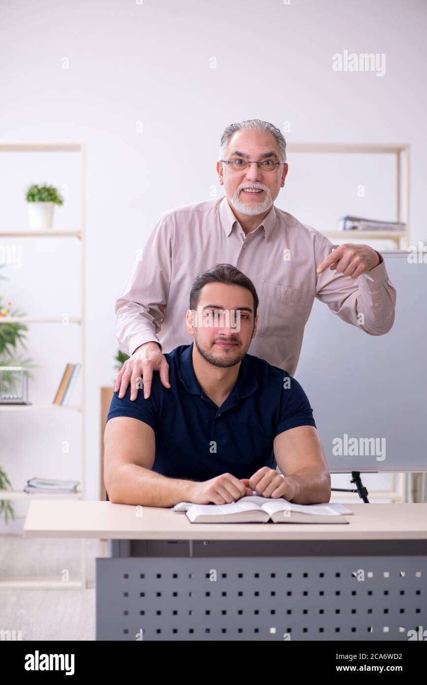 Old teacher and young student in the classroom Stock Photo - Alamy