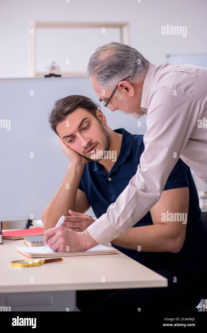 Old teacher and young student in the classroom Stock Photo - Alamy