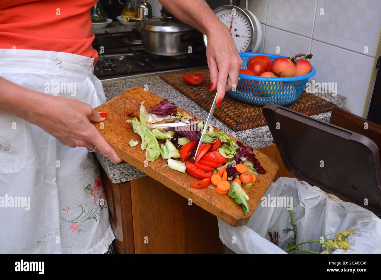 Detail of a female hand disposing of organic waste in a proper bin with ...