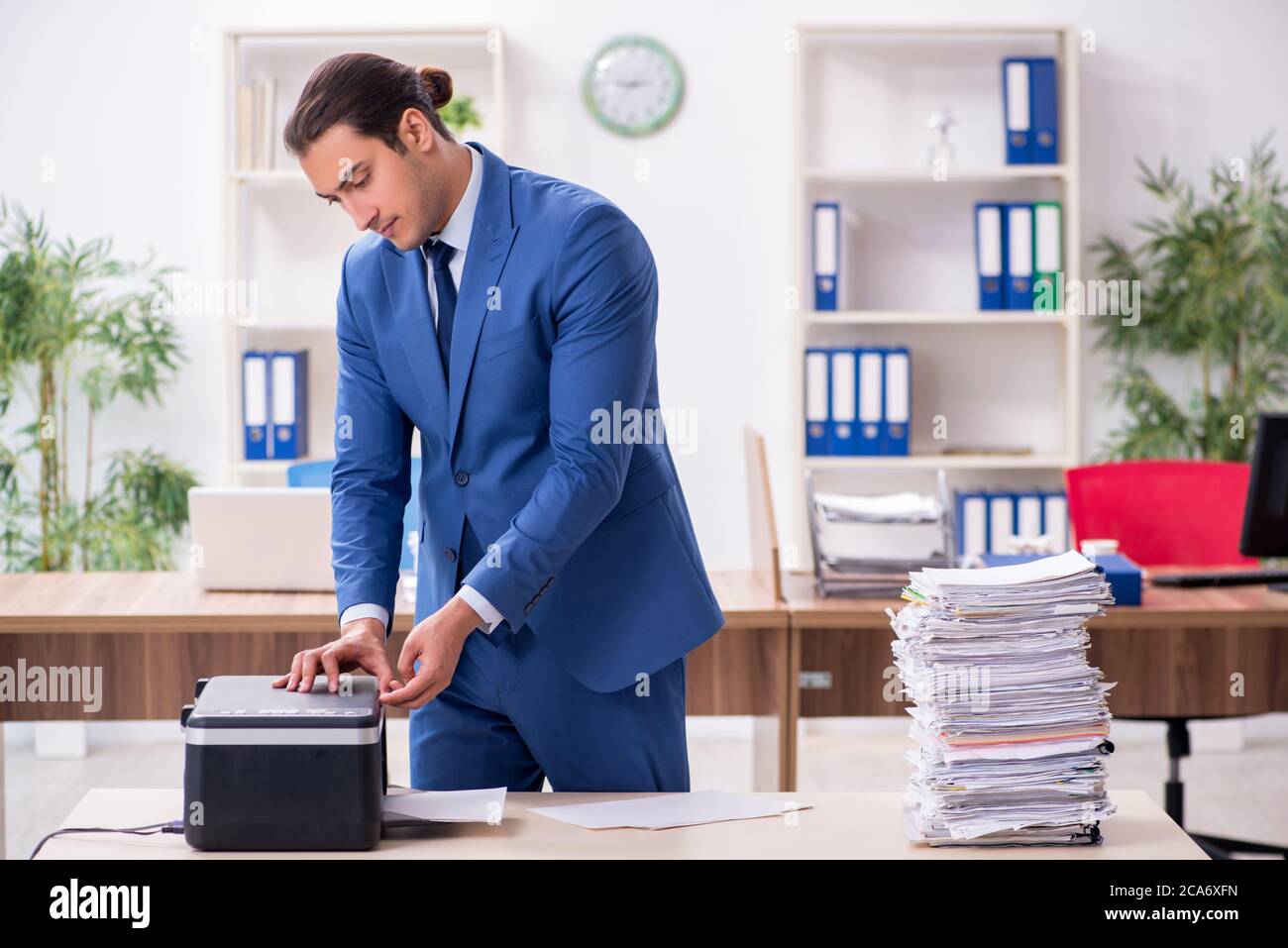 Young employee making copies at copying machine Stock Photo - Alamy