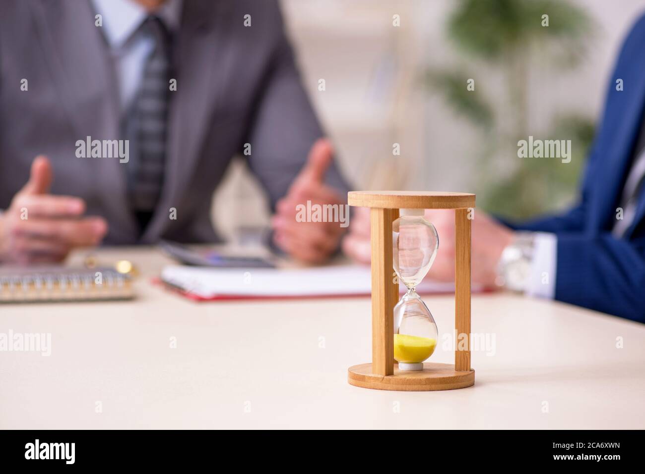 Two businessmen in the time management concept Stock Photo - Alamy