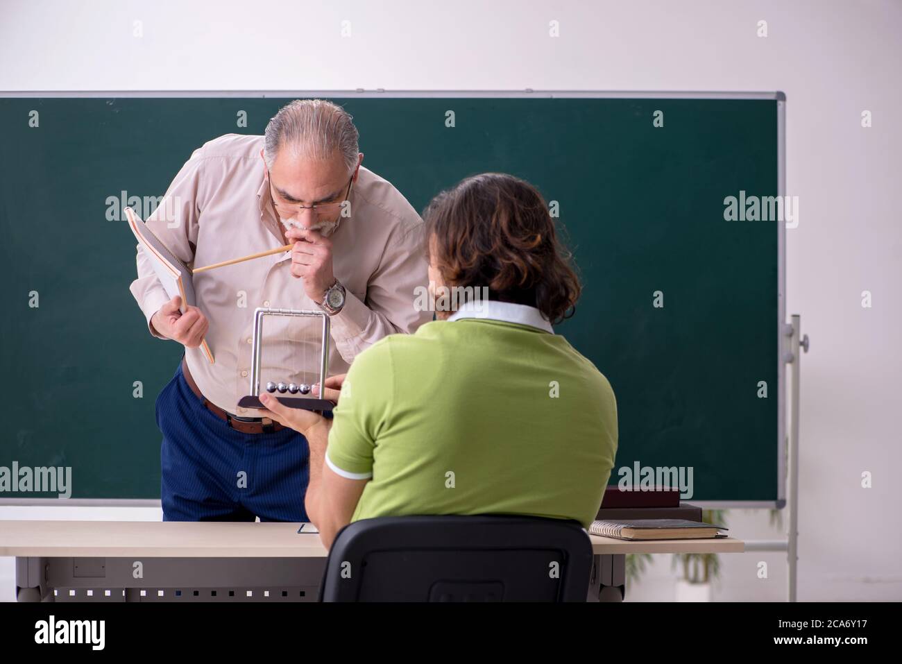 Old professor physicist and student in the classroom Stock Photo - Alamy