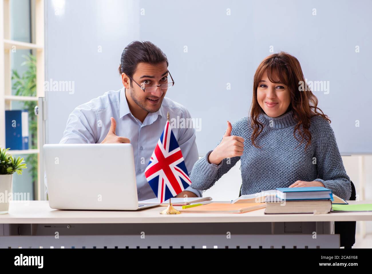 Young student and male english teacher in the classroom Stock Photo - Alamy