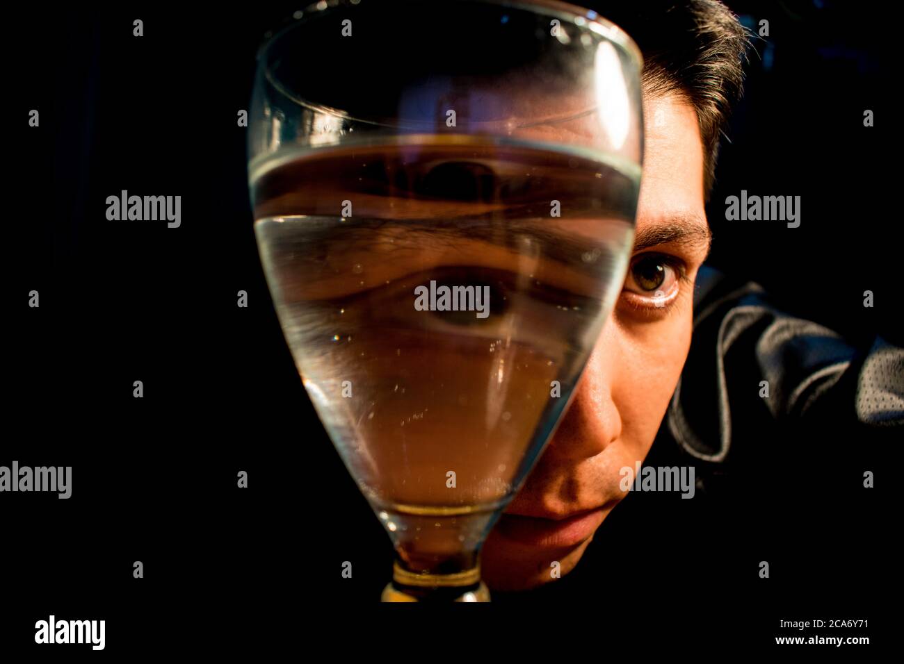 man with a glass of water deforming his face Stock Photo - Alamy