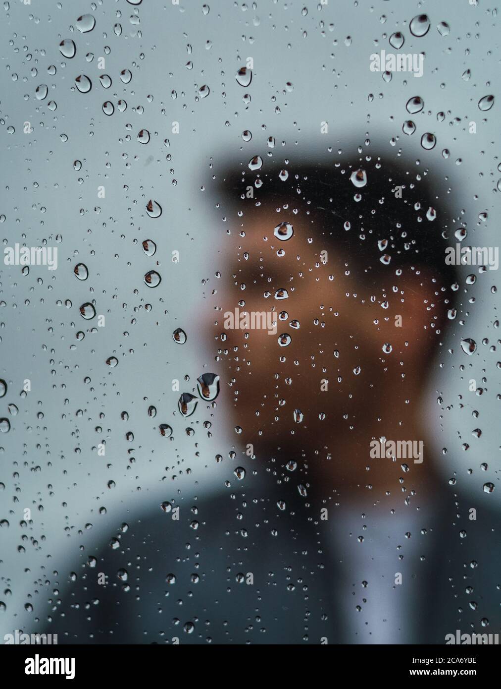 Reflection of man on glass while it rains Stock Photo - Alamy