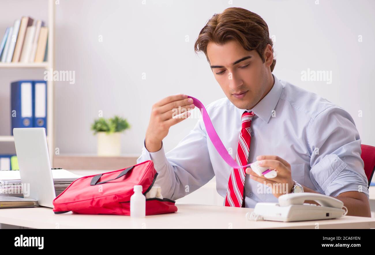The man with first aid kit in the office Stock Photo - Alamy