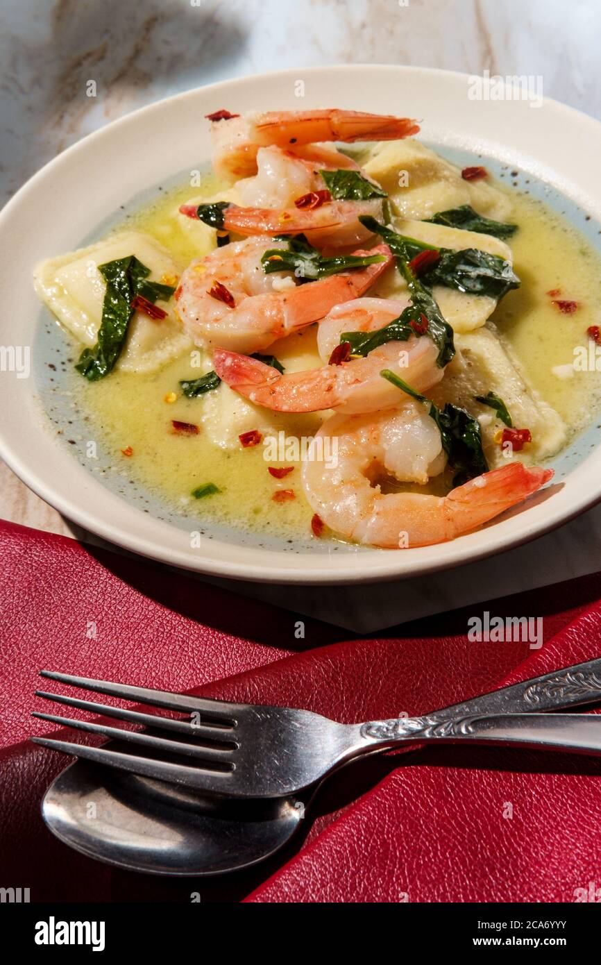 Tuscan creamy shrimp and cheese ravioli with spinach Stock Photo - Alamy