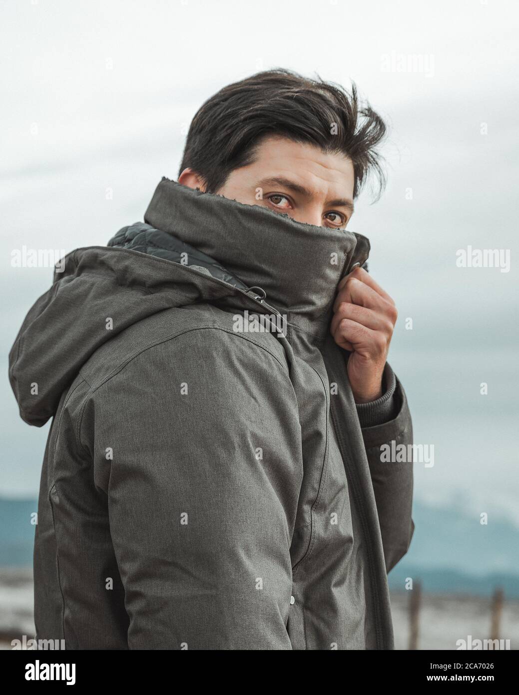 portrait of young man covering his face Stock Photo - Alamy