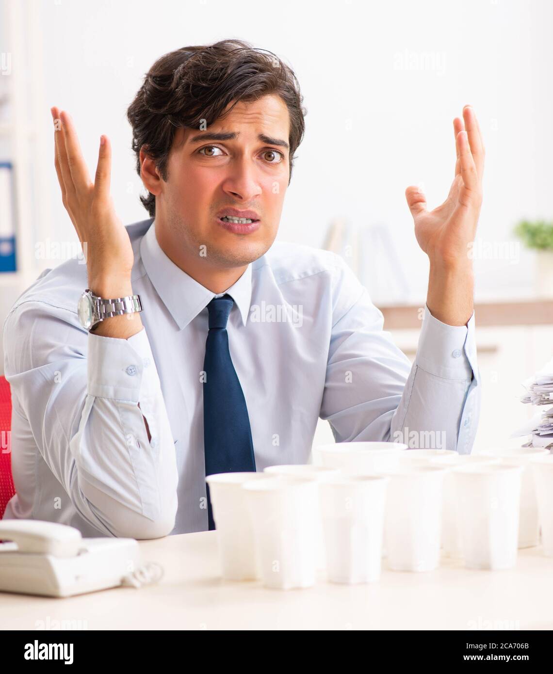 The young employee addicted to coffee Stock Photo - Alamy