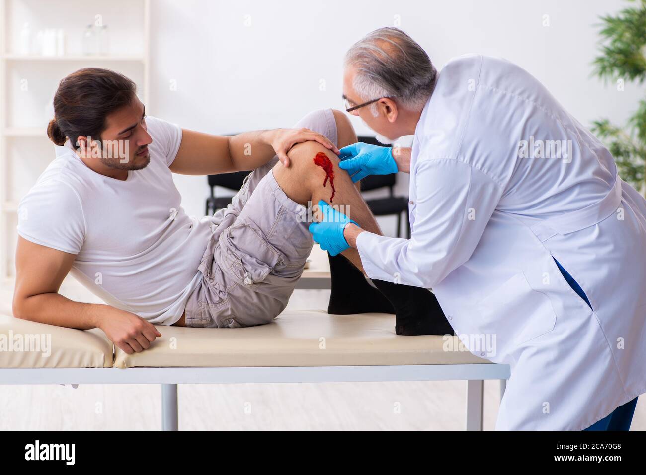 Leg injured man visiting doctor in first aid concept Stock Photo - Alamy