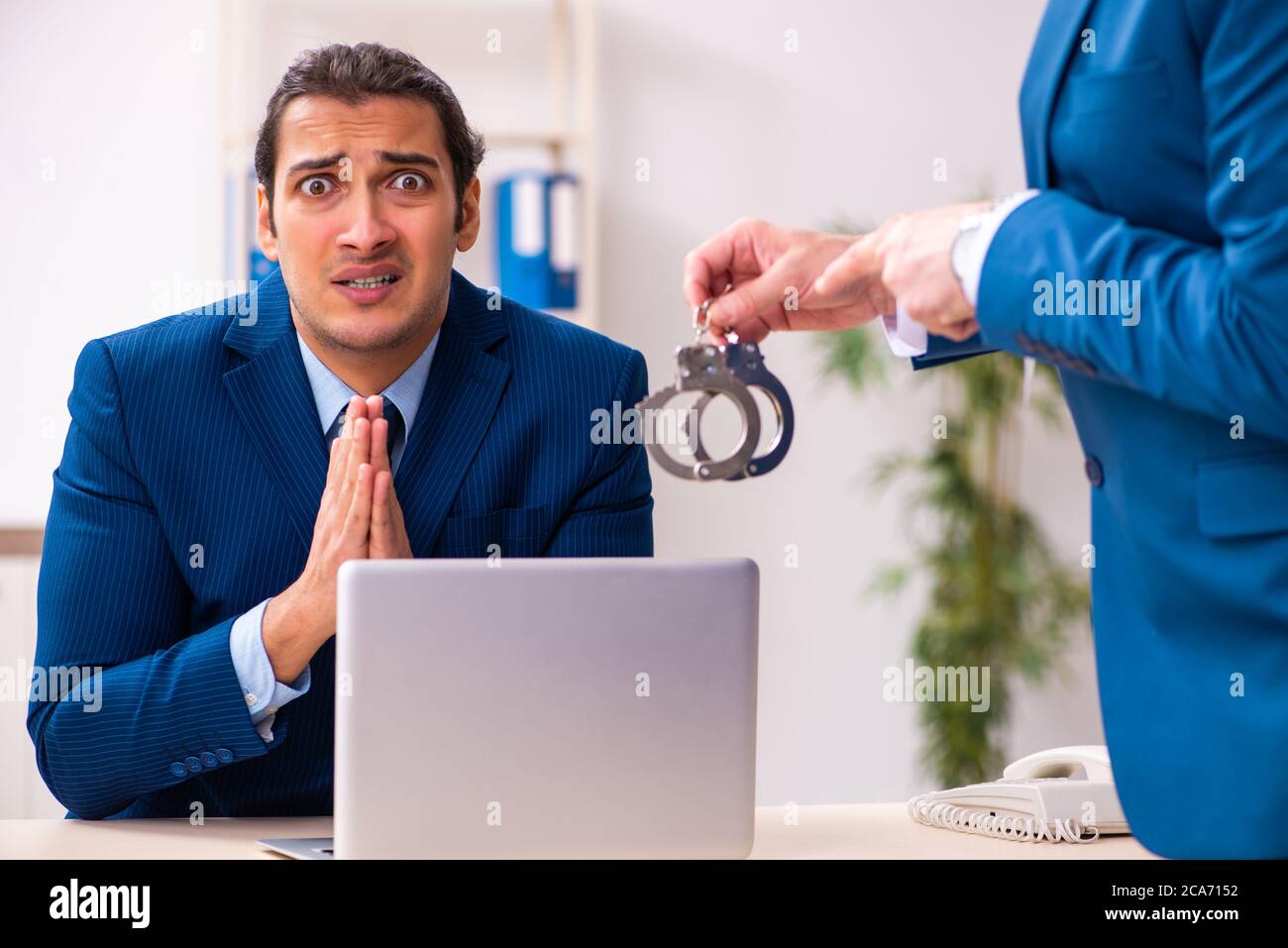 Male employee and cop in police investigation Stock Photo - Alamy