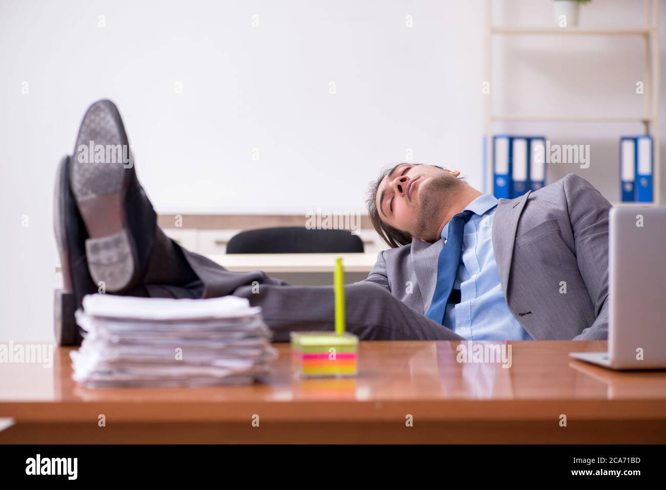 Young employee sleeping in the office Stock Photo - Alamy