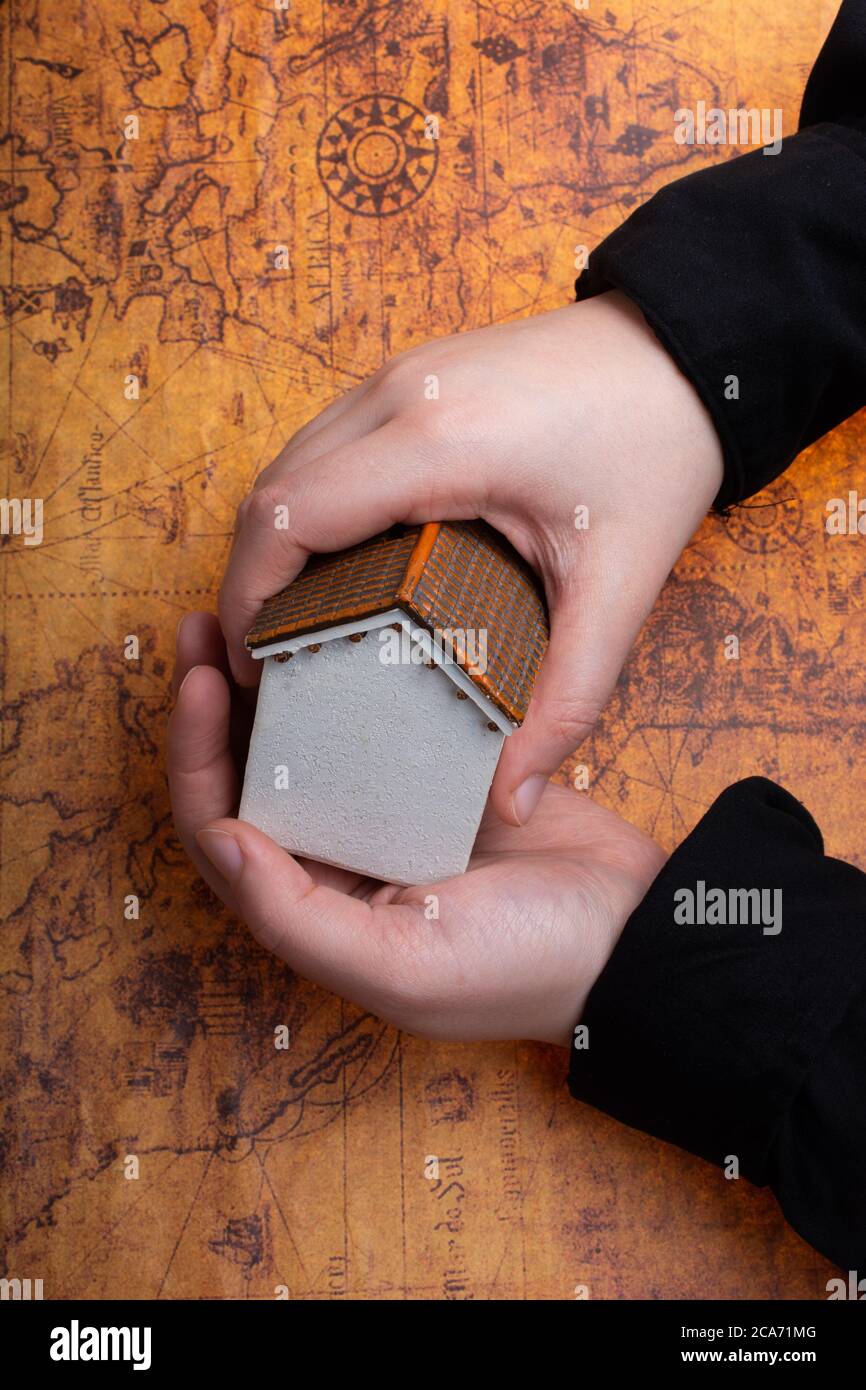 Model House on a vintage map background held by hands Stock Photo - Alamy