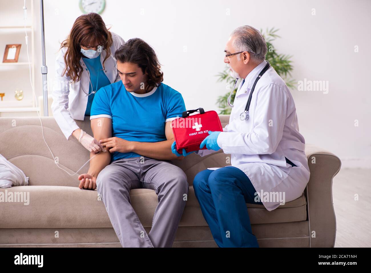 Two doctors visiting sick man at home Stock Photo - Alamy