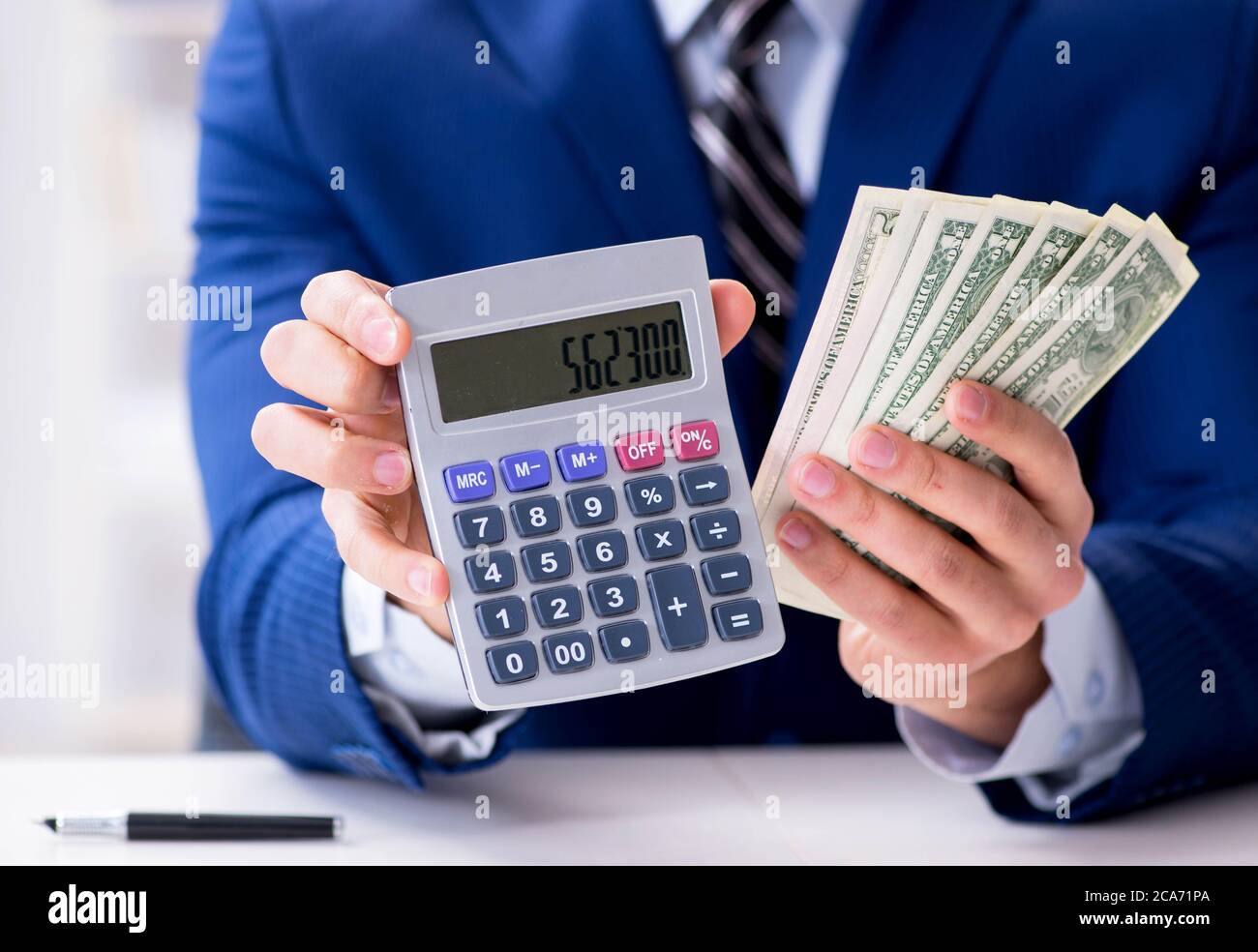 The accountant calculating dollars with calculator in office Stock ...