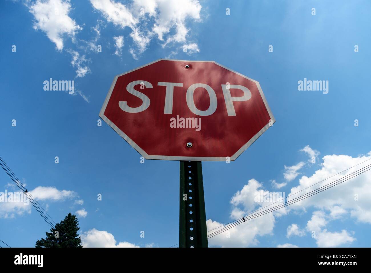 Stop sign with bright blue sky with fluffy clouds Stock Photo - Alamy