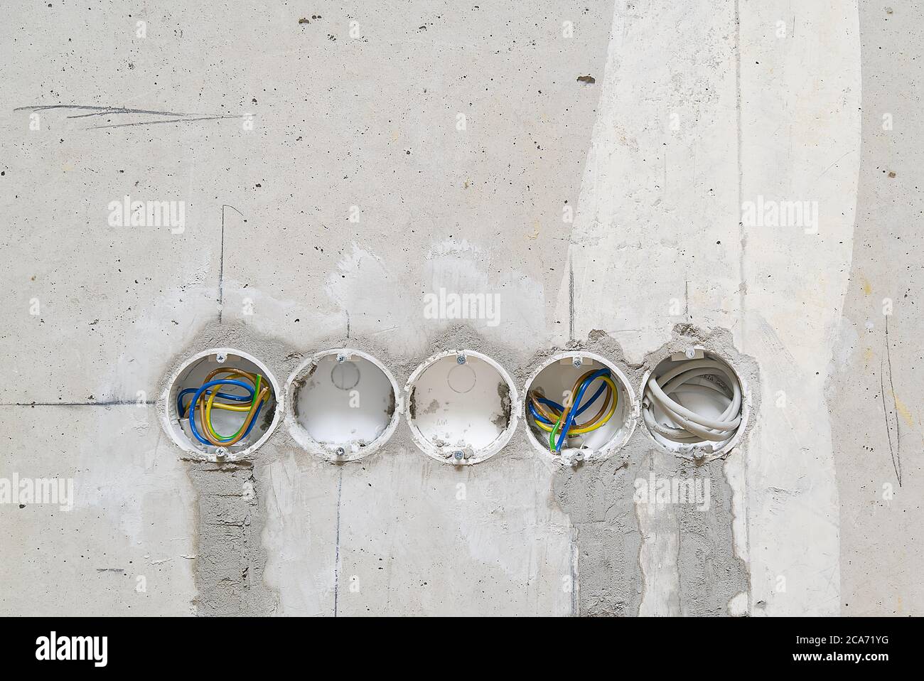 Holes in a concrete wall for installing plastic boxes under sockets ...