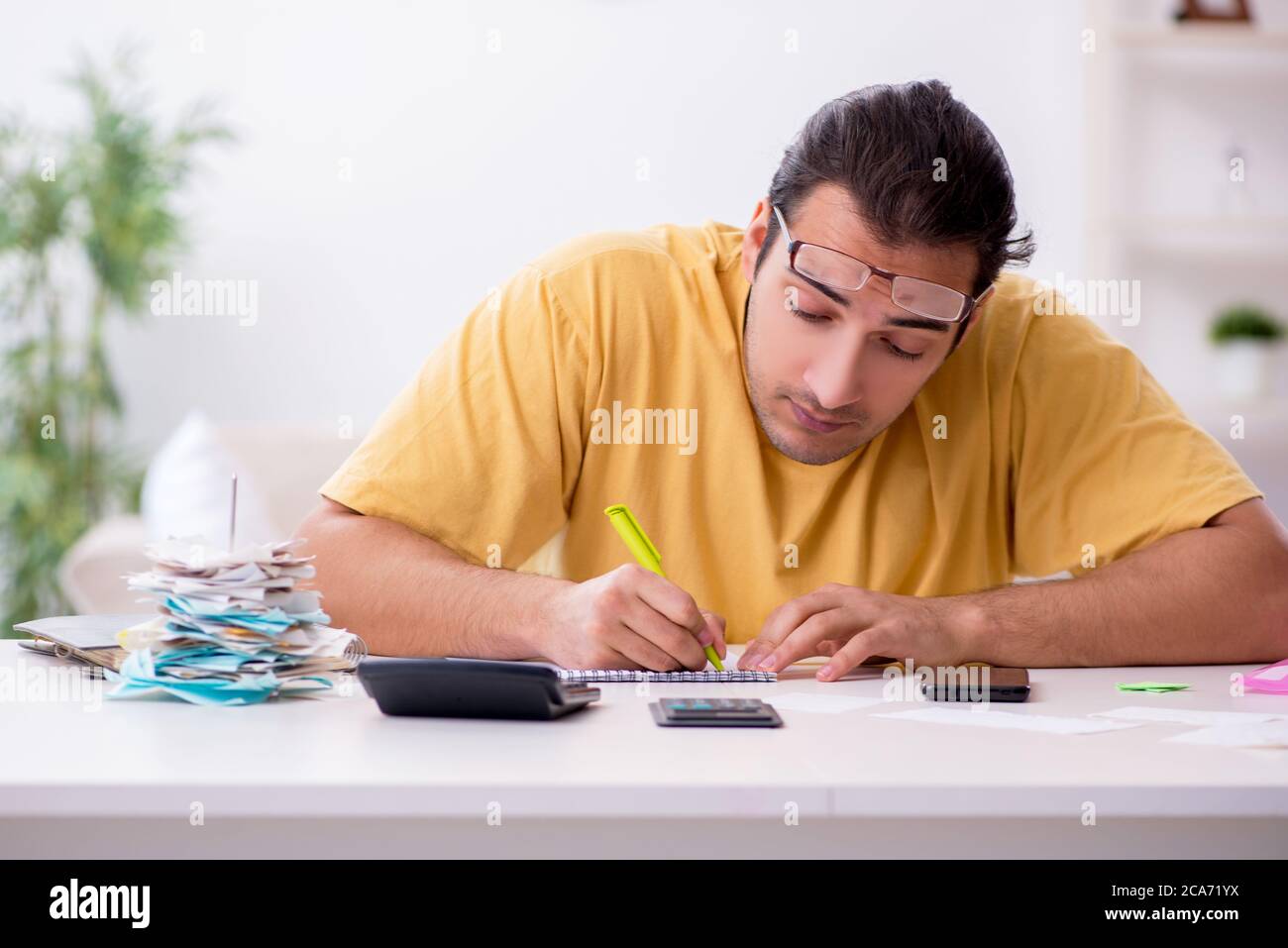 Young man in the budget planning concept Stock Photo - Alamy